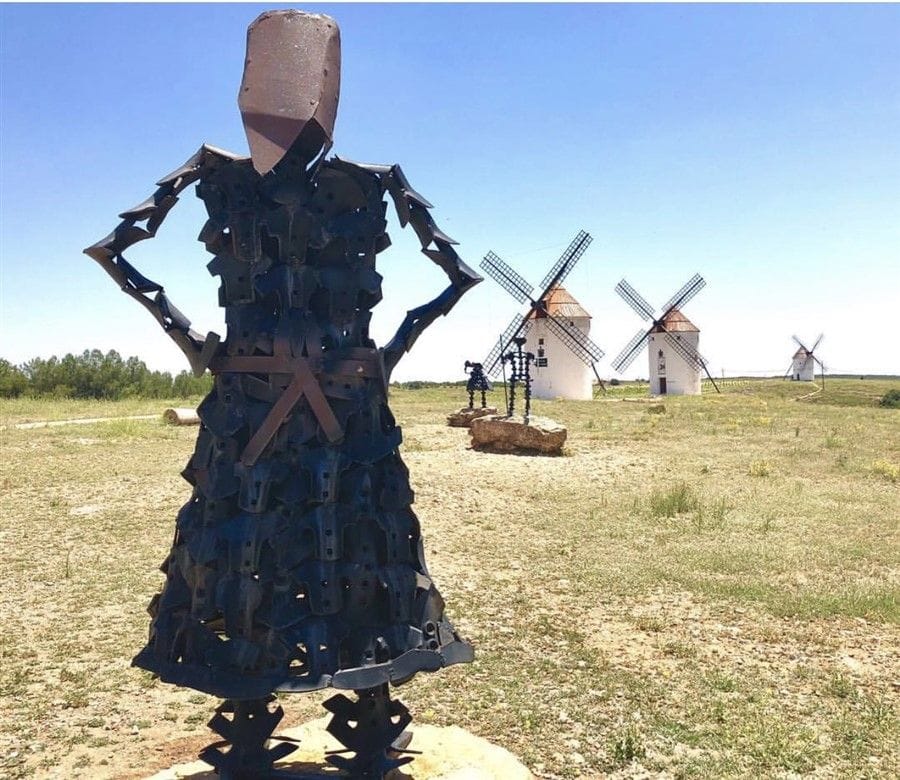 Dulcinea del Toboso looks at Don Quixote in front of a windmill. | Winebus